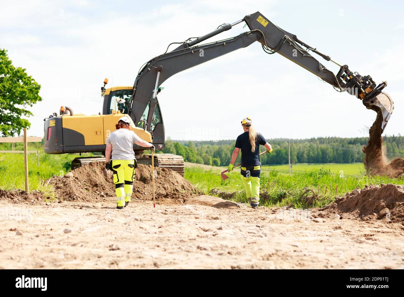 Female workers with digger on background Stock Photo - Alamy