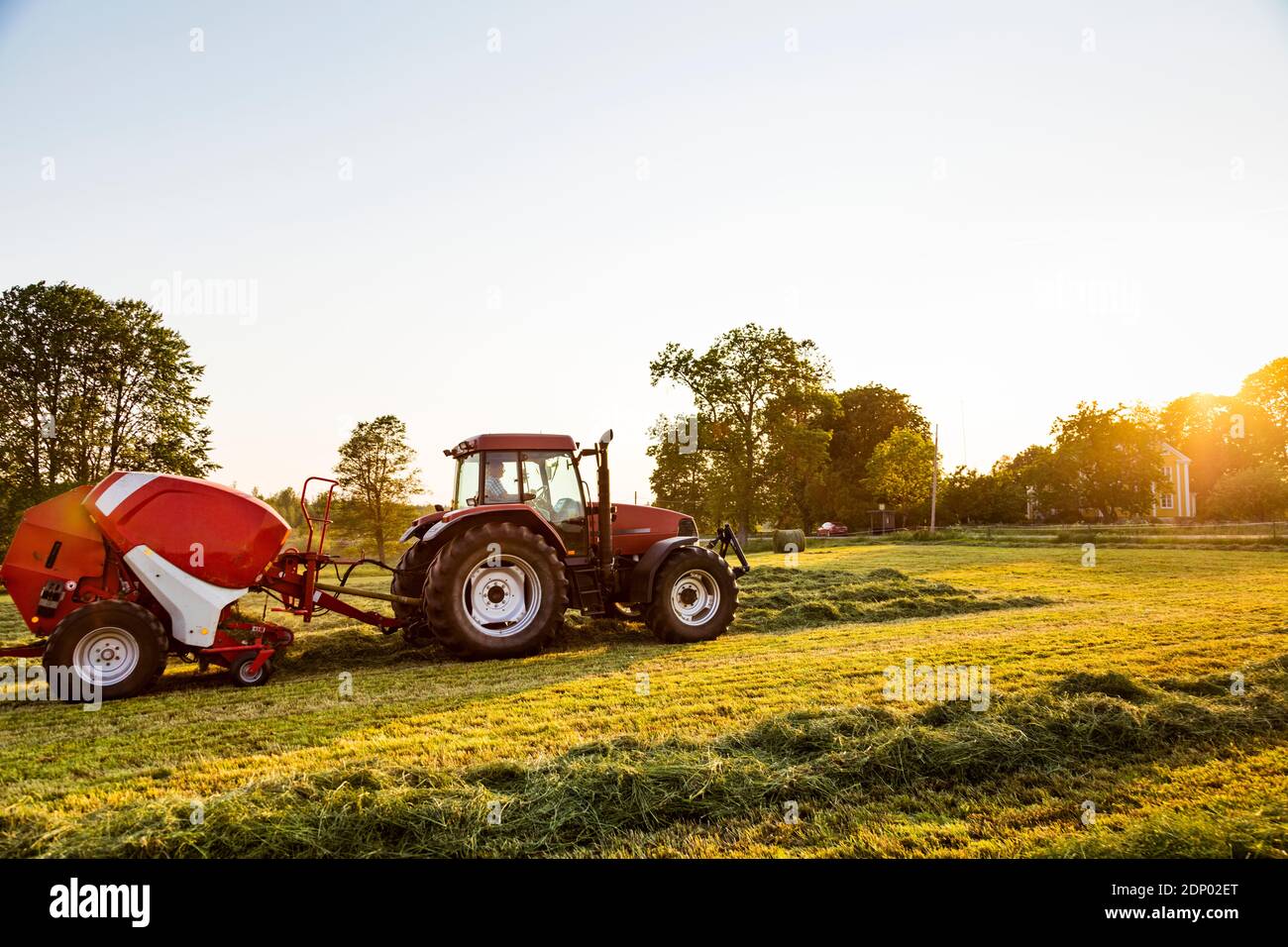 Tractor on field at sunset Stock Photo - Alamy