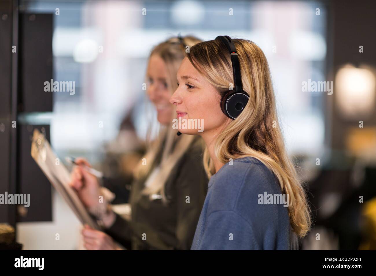 Woman wearing headset in office Stock Photo - Alamy