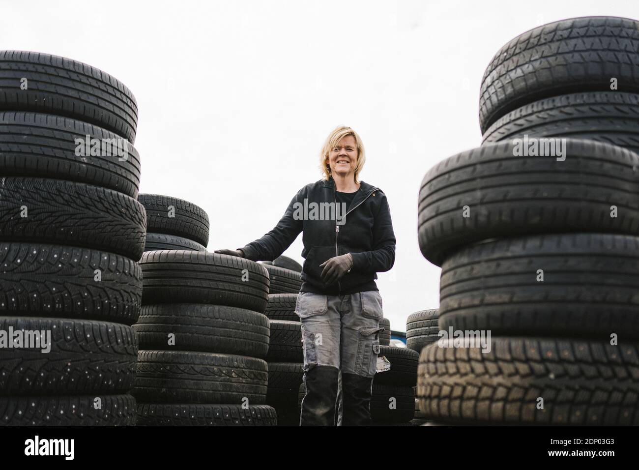 Female mechanic stacking car tires Stock Photo - Alamy