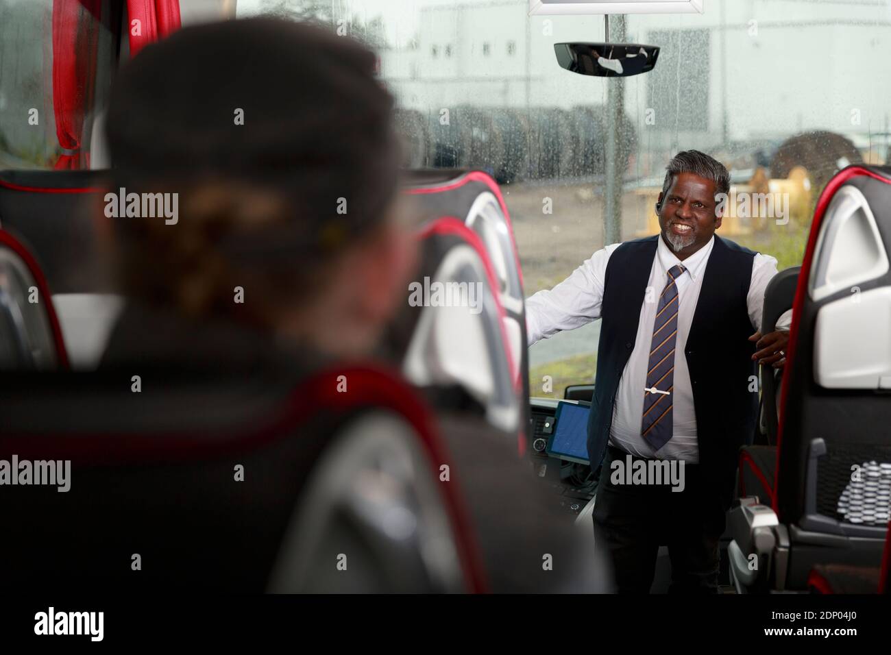 Smiling driver standing in bus Stock Photo - Alamy