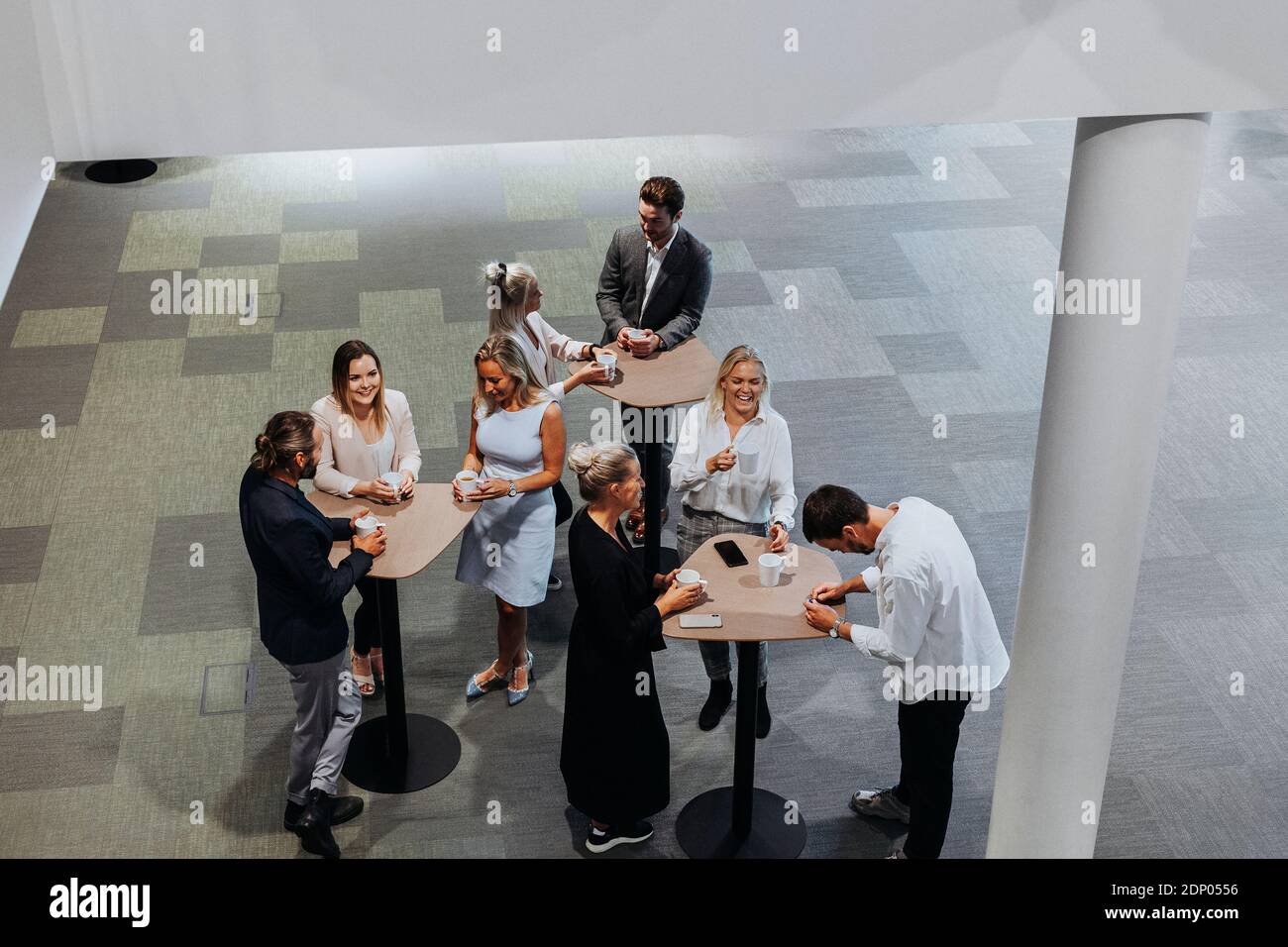 Coworkers talking on corridor Stock Photo - Alamy