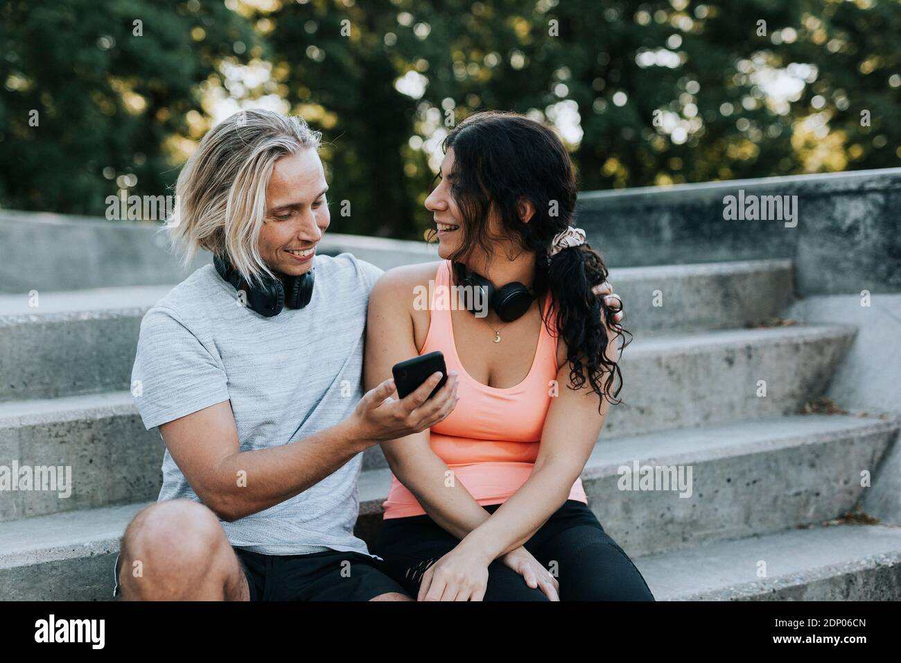 Smiling couple sitting on steps Stock Photo - Alamy