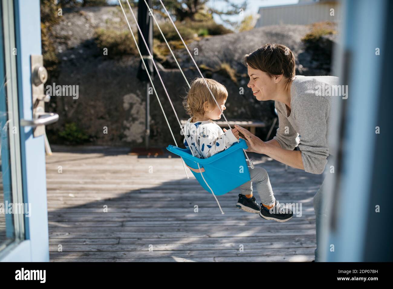Mother swinging daughter Stock Photo - Alamy
