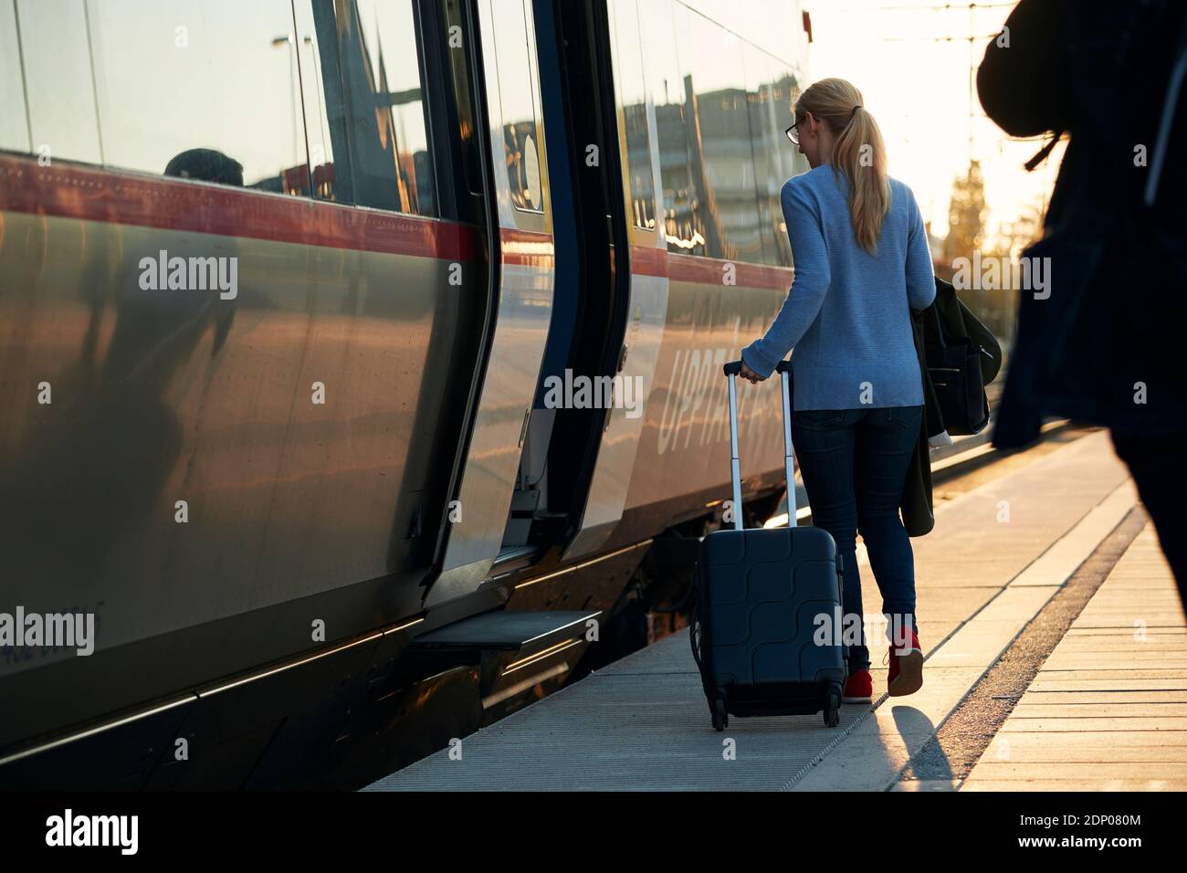 Woman entering train at station Stock Photo - Alamy