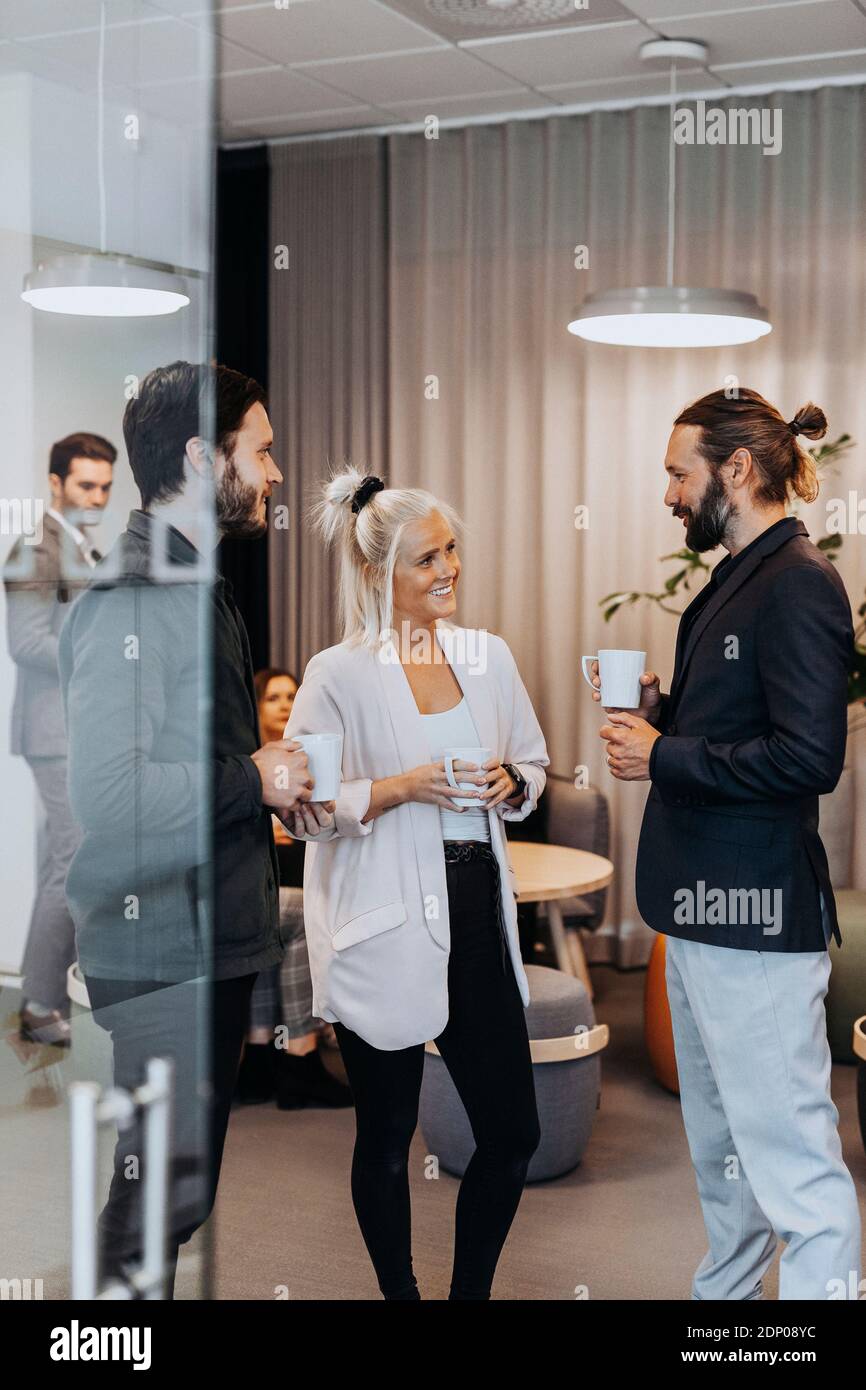 Coworkers talking on corridor Stock Photo - Alamy