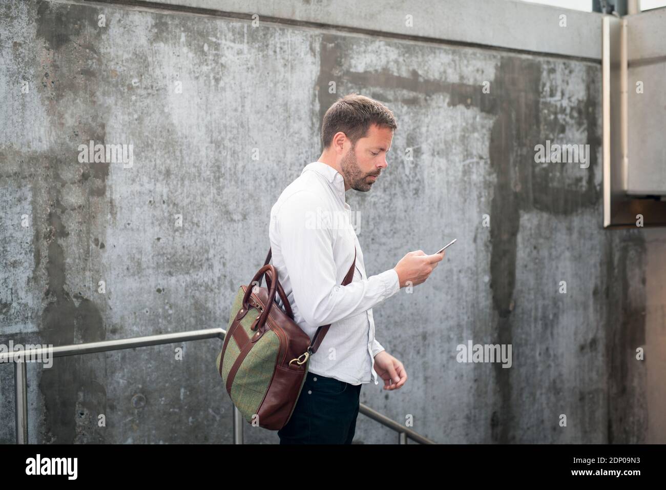 Checking smartphone commuter standing hi-res stock photography and ...