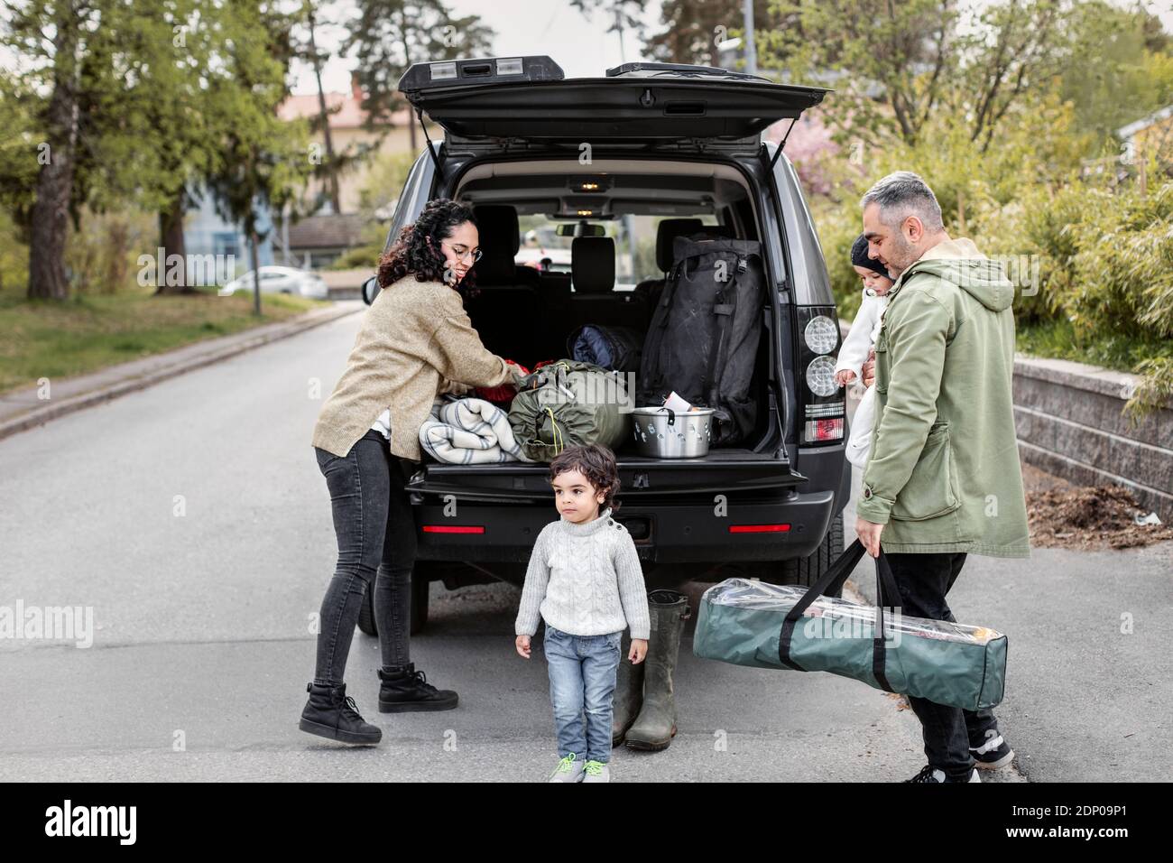 Parents with children near car Stock Photo - Alamy
