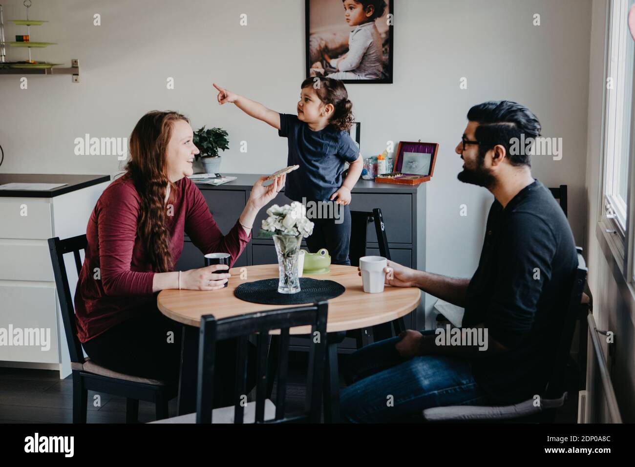 Girl with parents at table Stock Photo - Alamy