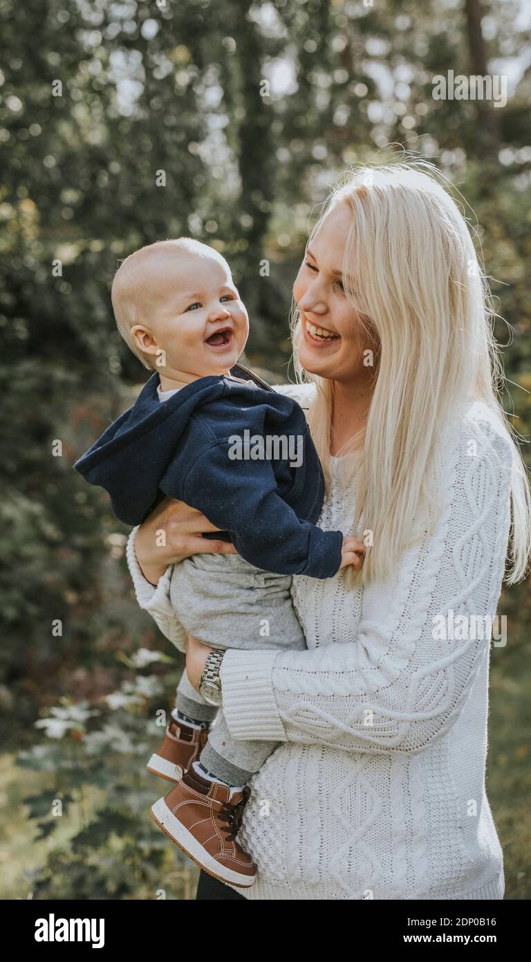 Mother carrying baby Stock Photo - Alamy