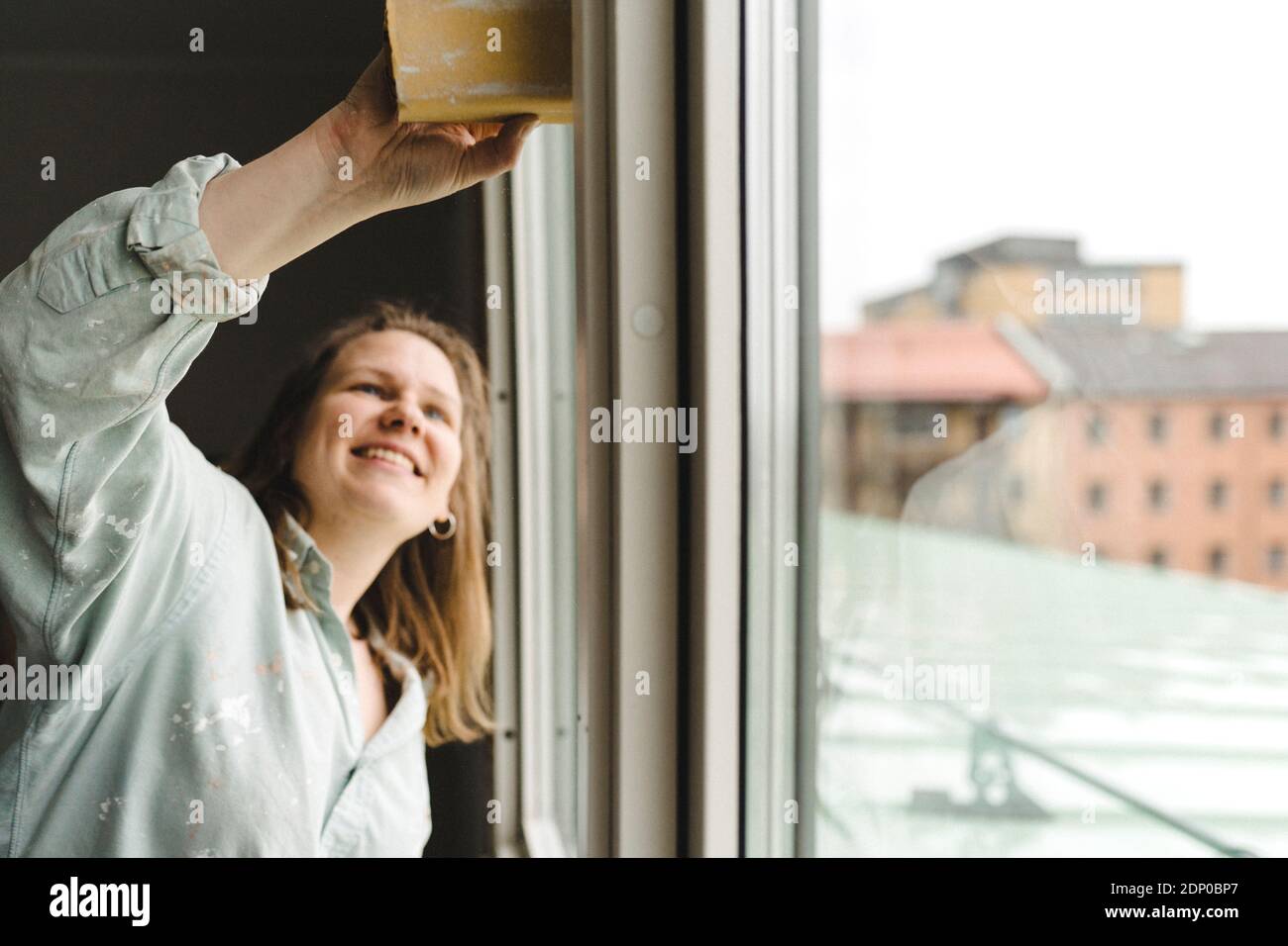 Woman sanding window frame Stock Photo - Alamy