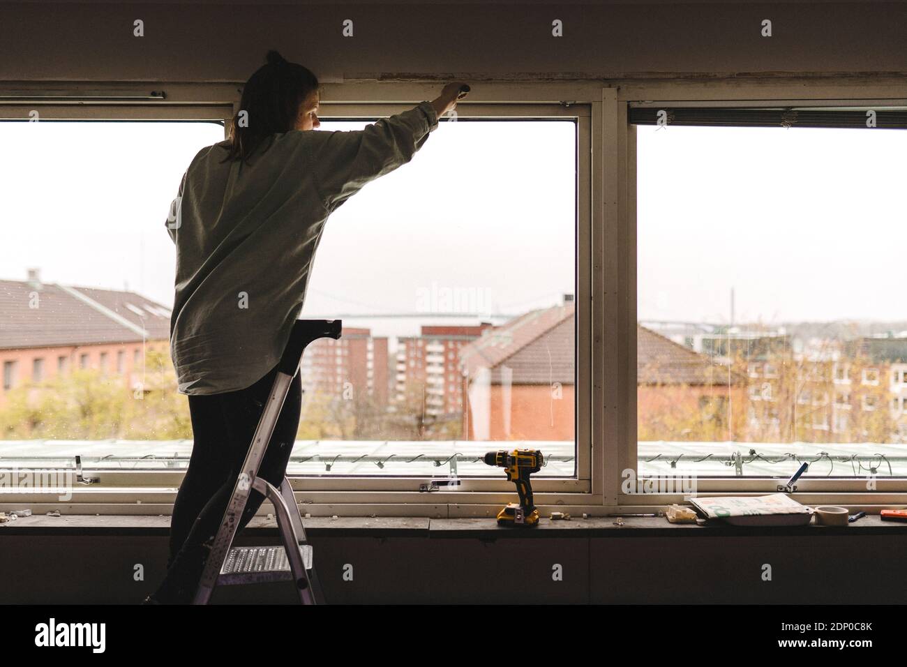 Woman sanding window frame Stock Photo - Alamy