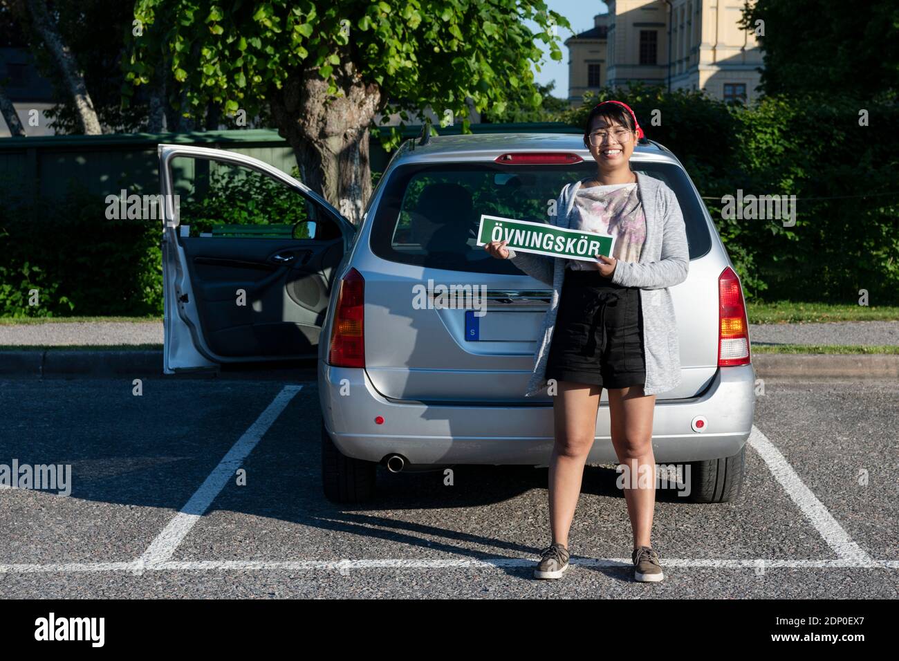 Female student driver holding sign Stock Photo - Alamy