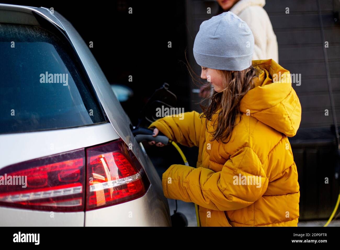 Girl charging electric car Stock Photo - Alamy