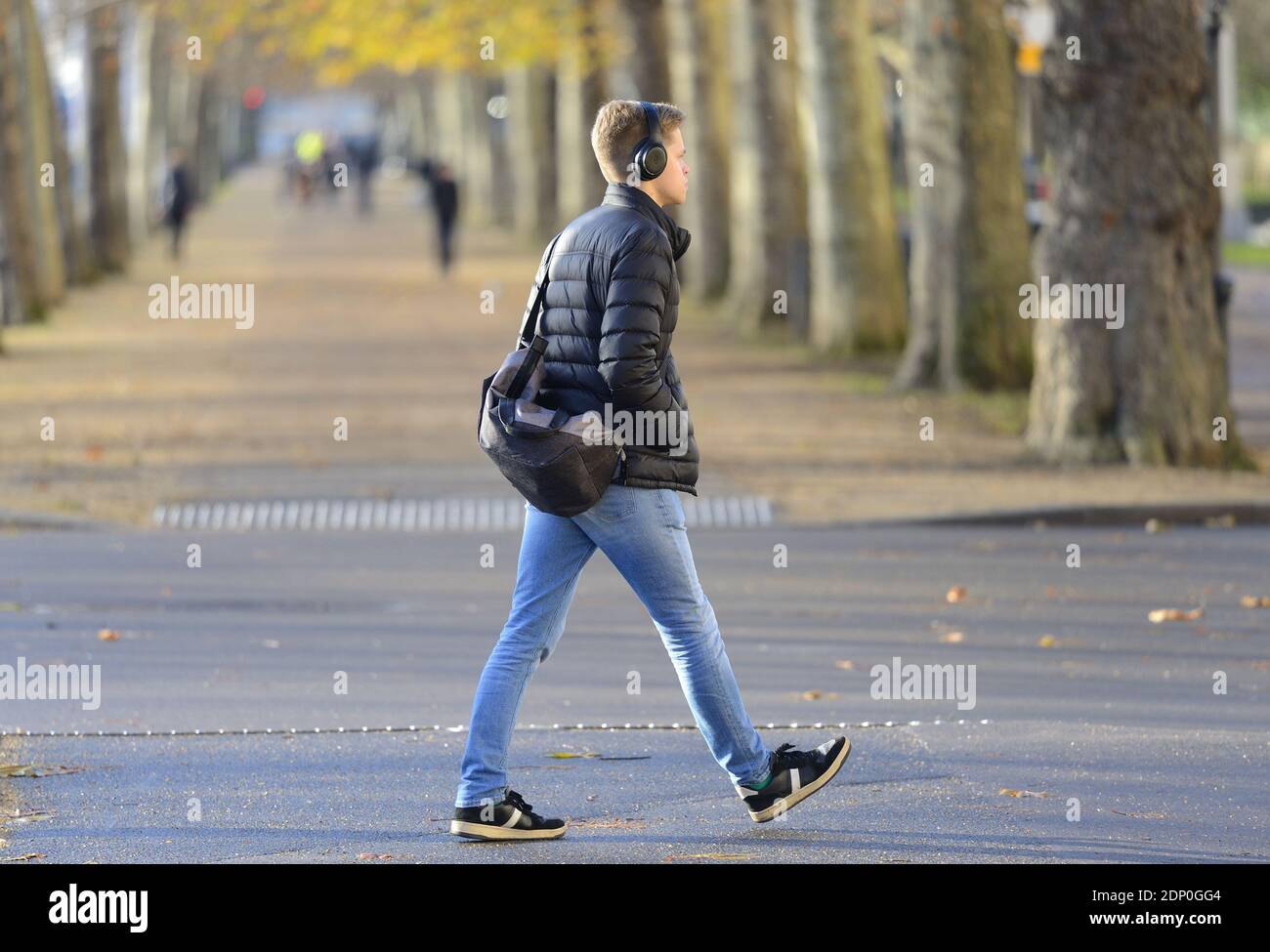 London, England, UK. Young man wearing headphones walking in The Mall ...