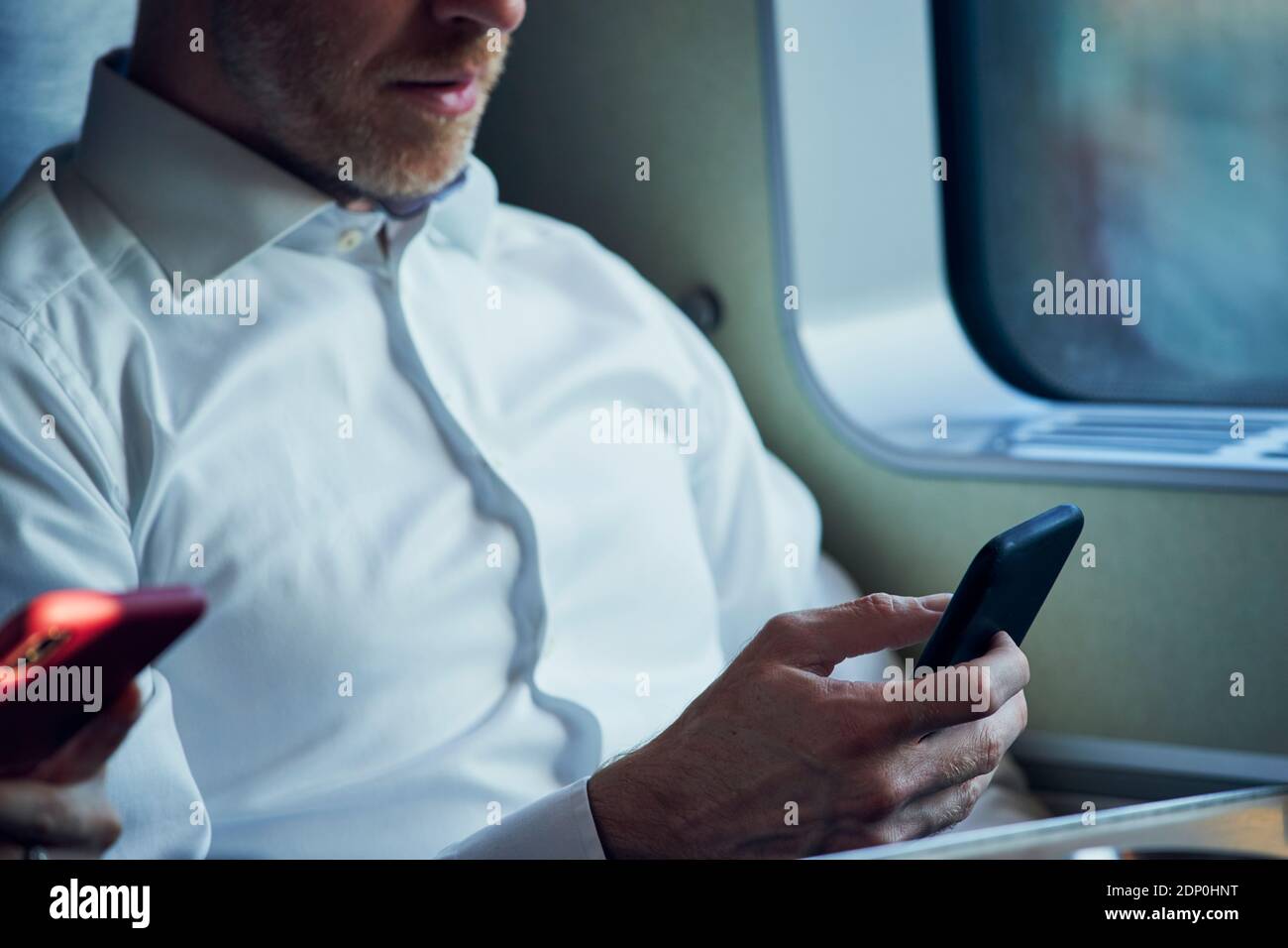 Man in train using cell phone Stock Photo - Alamy