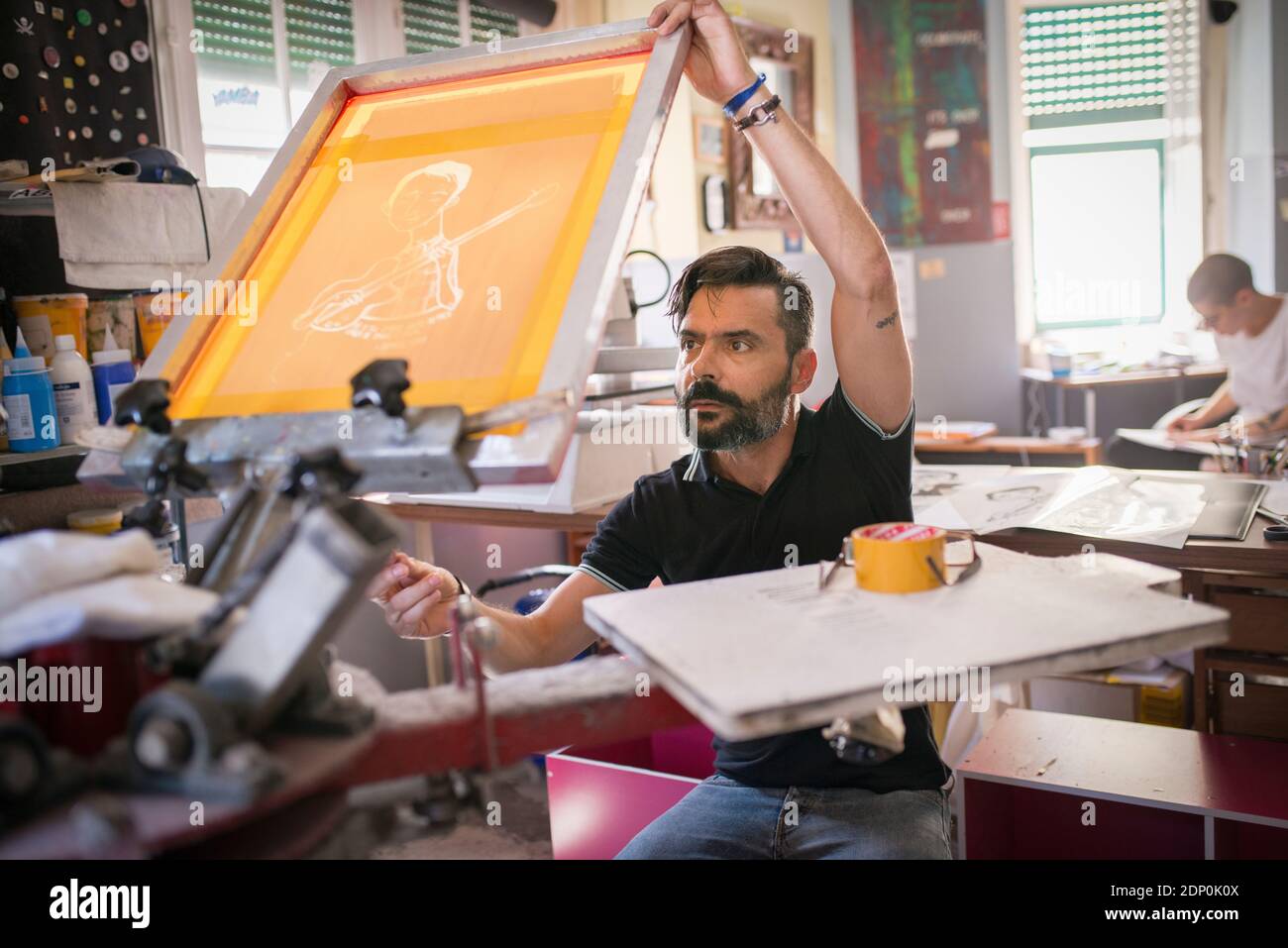 Man operating screen printing equipment Stock Photo - Alamy