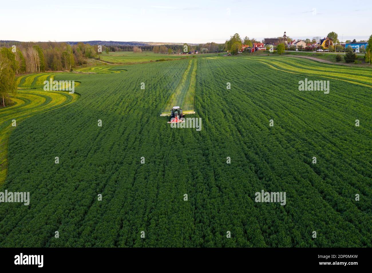 Tractor harvesting field Stock Photo - Alamy