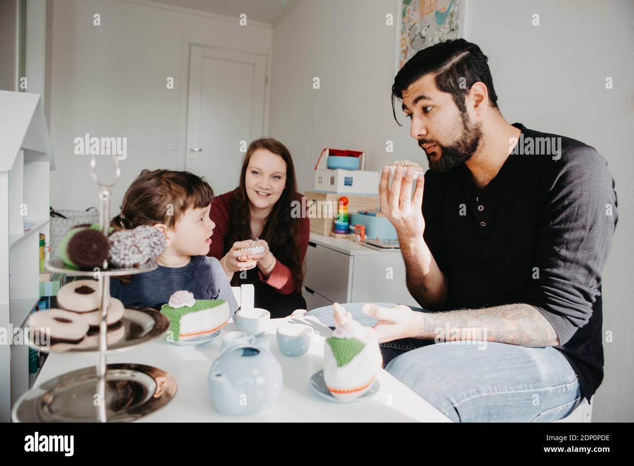 Girl having tea party with parents Stock Photo - Alamy