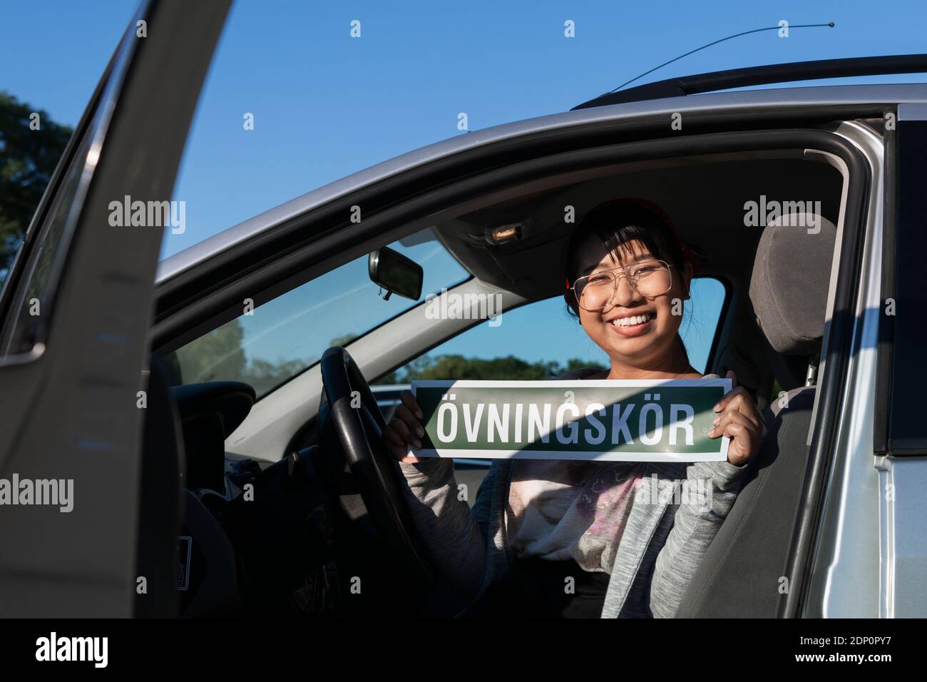 Female student driver holding sign Stock Photo - Alamy