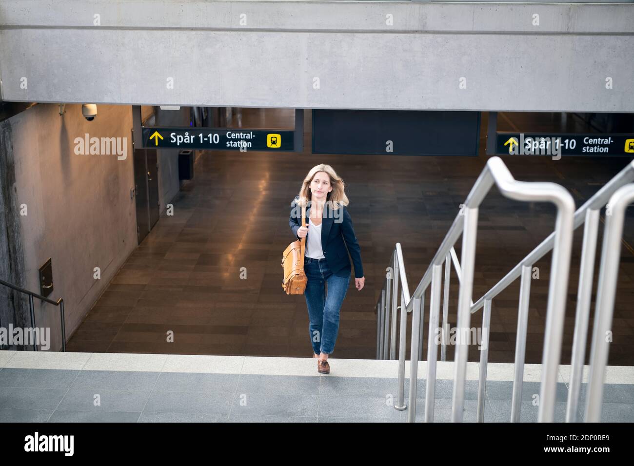 Woman walking upstairs from train station Stock Photo - Alamy
