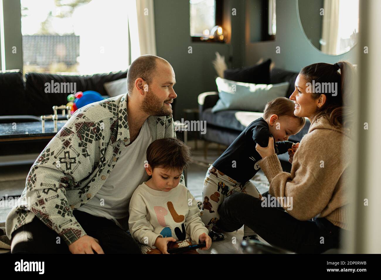 Parents with children in living room Stock Photo - Alamy