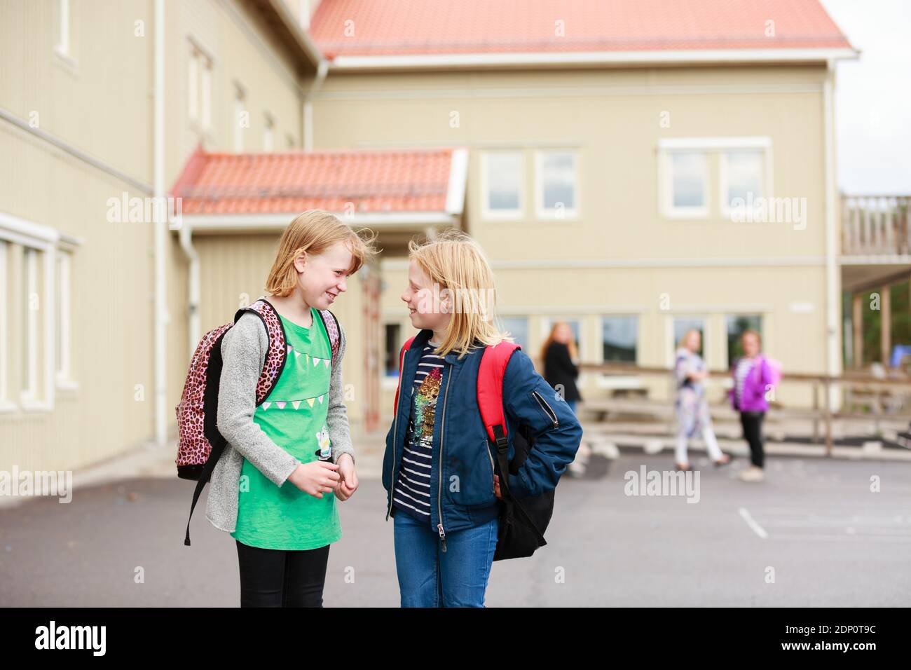 Smiling girls in front of school building Stock Photo - Alamy