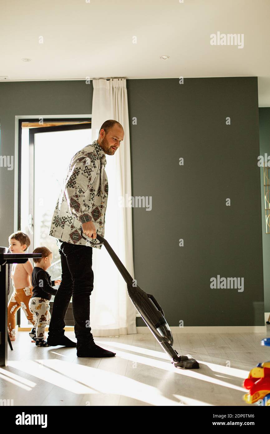 Man vacuum cleaning room Stock Photo - Alamy