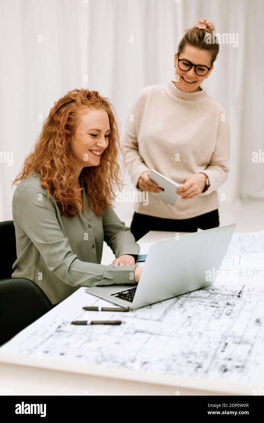 Female coworkers talking in office Stock Photo - Alamy