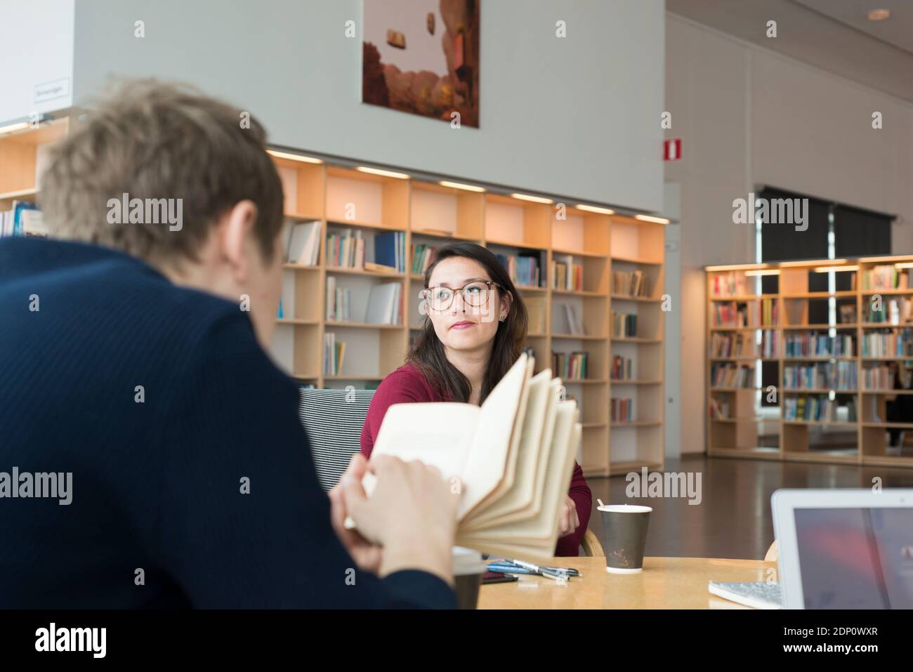 Woman sitting in library Stock Photo - Alamy