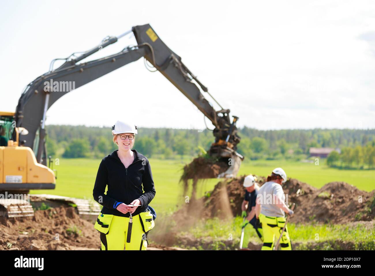 Female worker with digger on background Stock Photo - Alamy