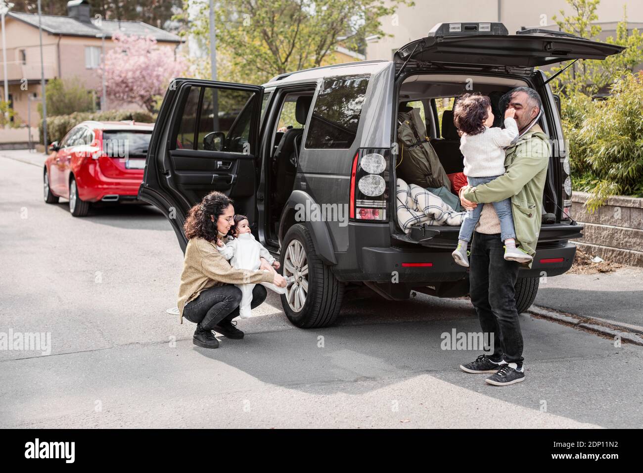 Parents with children near car Stock Photo - Alamy