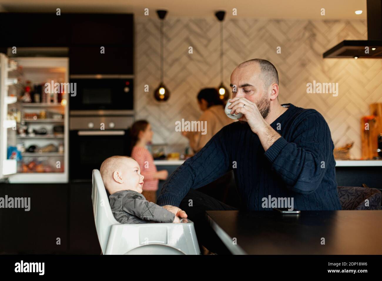 Father with baby at table Stock Photo - Alamy