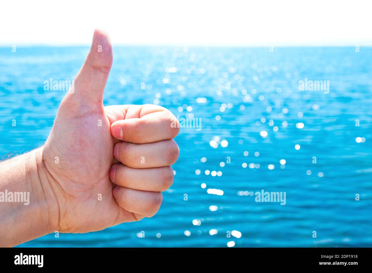 hand giving thumb up against the sea Stock Photo - Alamy