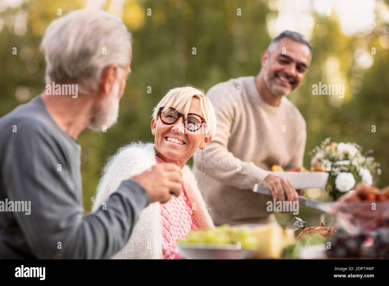 Happy family sitting garden table hi-res stock photography and images ...