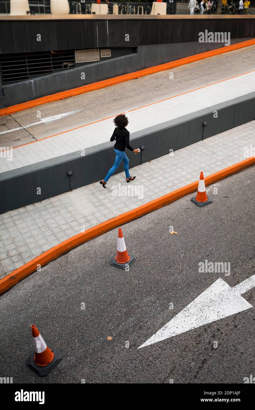Back view of businesswoman running on pavement Stock Photo - Alamy