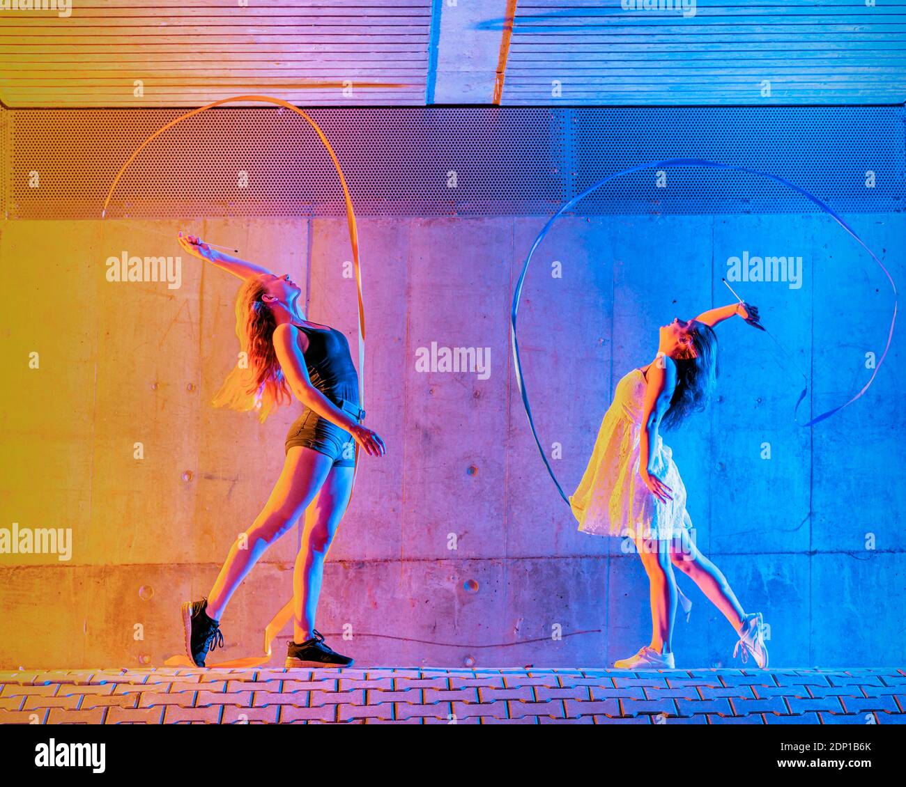 Women spinning ribbon while standing against wall Stock Photo - Alamy