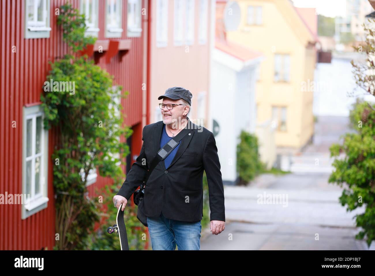 Smiling man walking along street Stock Photo - Alamy