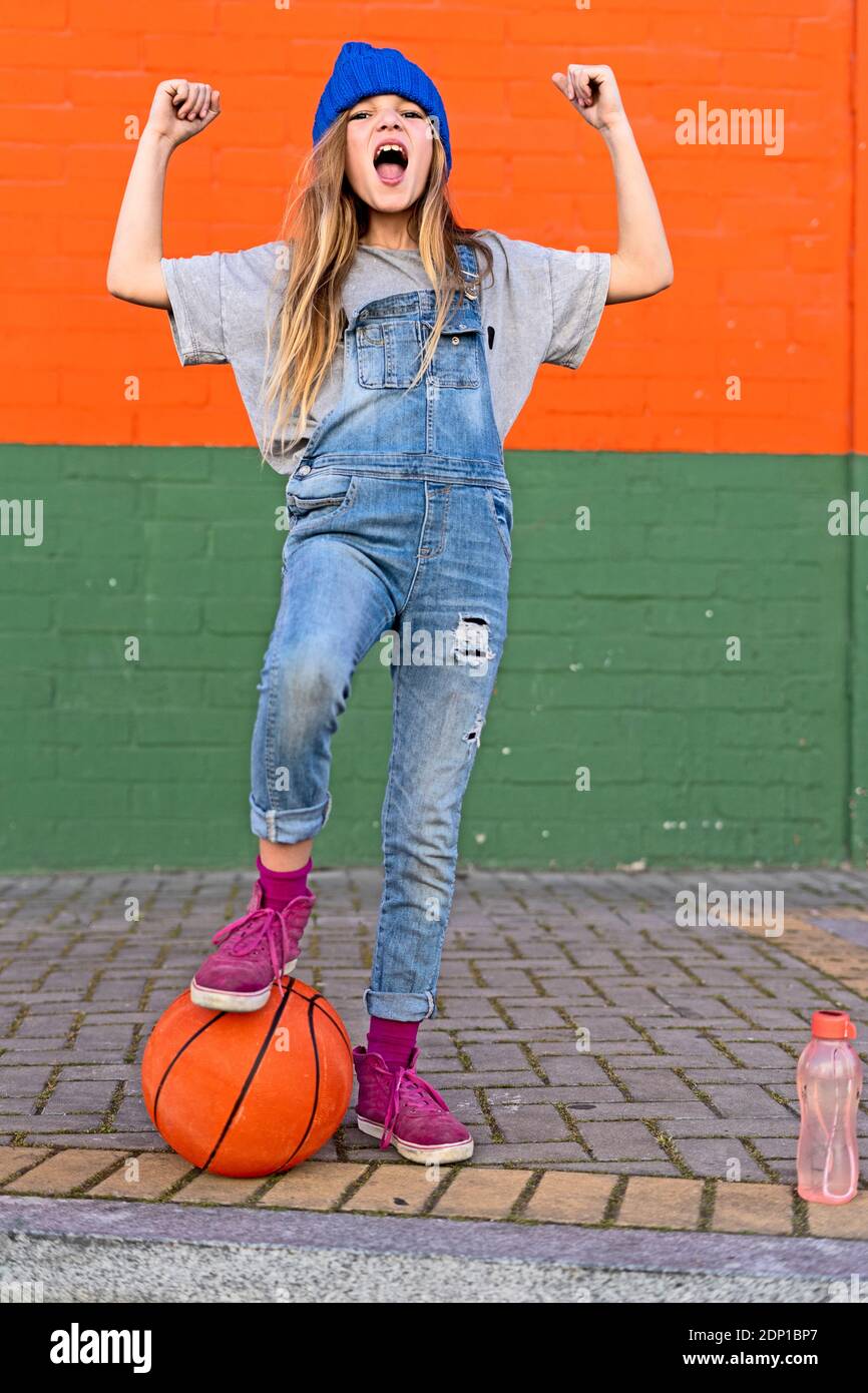 Young girl with foot on basketball Stock Photo - Alamy