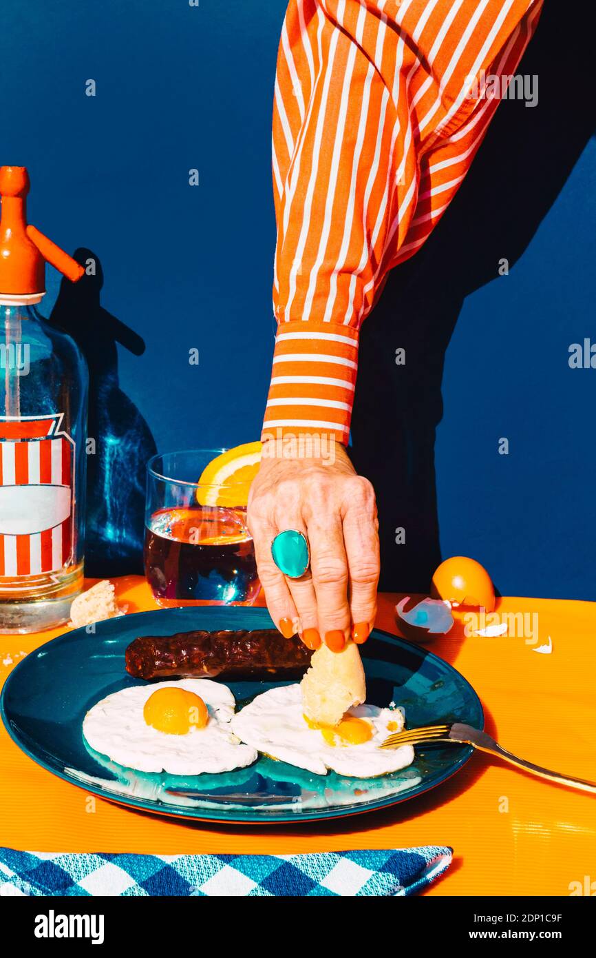 Arm of woman eating fried eggs with chorizo Stock Photo - Alamy