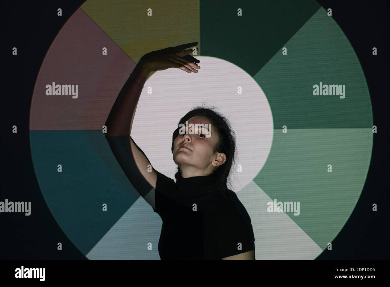 Young woman moving in front of color circke Stock Photo - Alamy