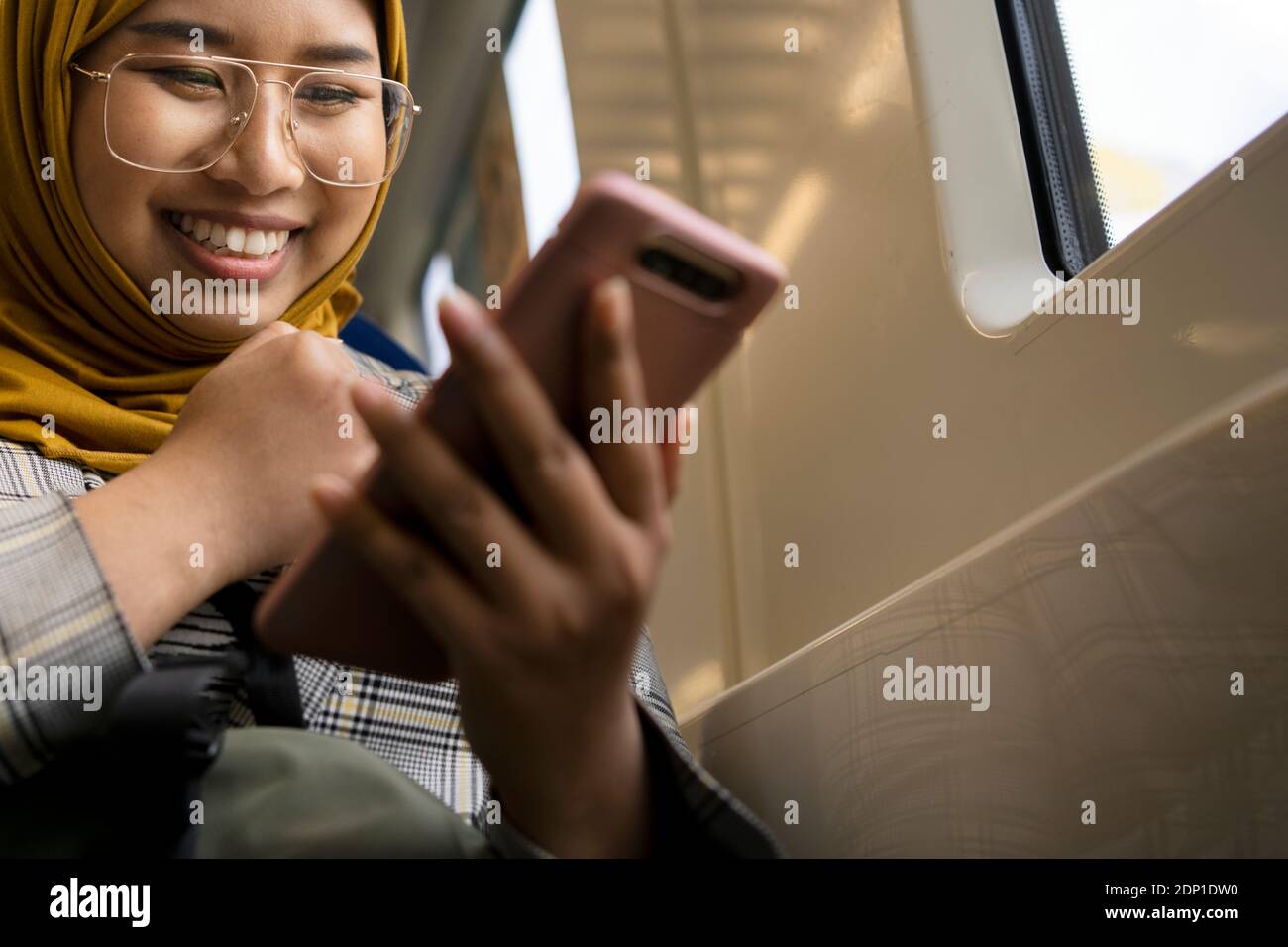 Woman in train using cell phone Stock Photo - Alamy