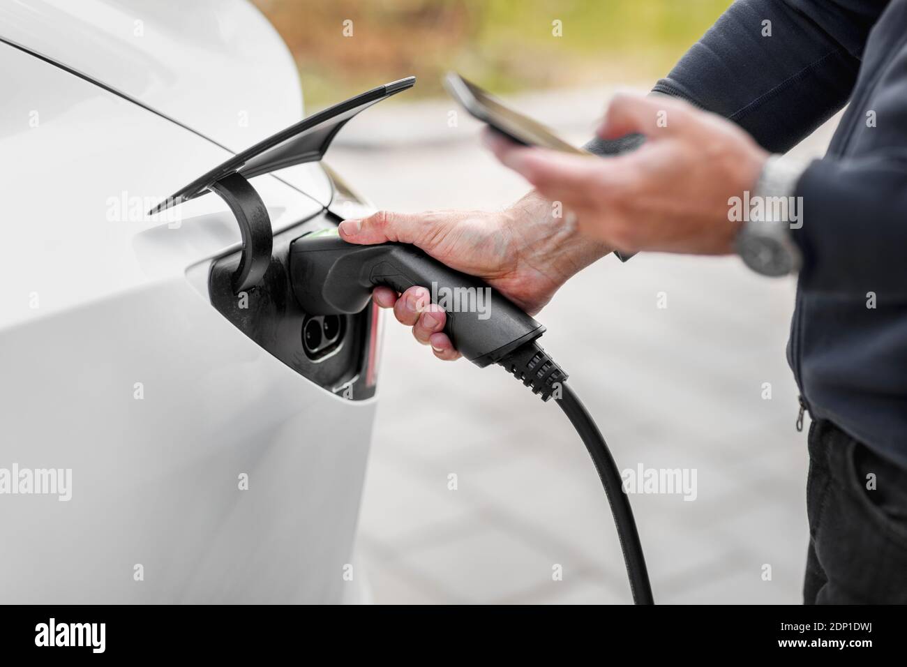 Mans hand holding car charger Stock Photo - Alamy