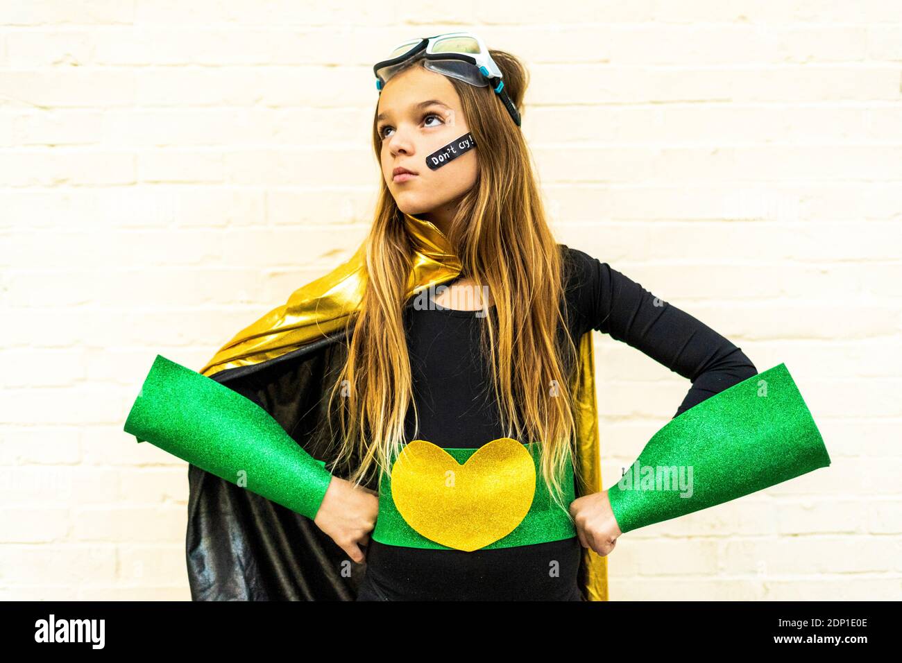 Girl in super heroine costume with band-aid on cheek Stock Photo - Alamy