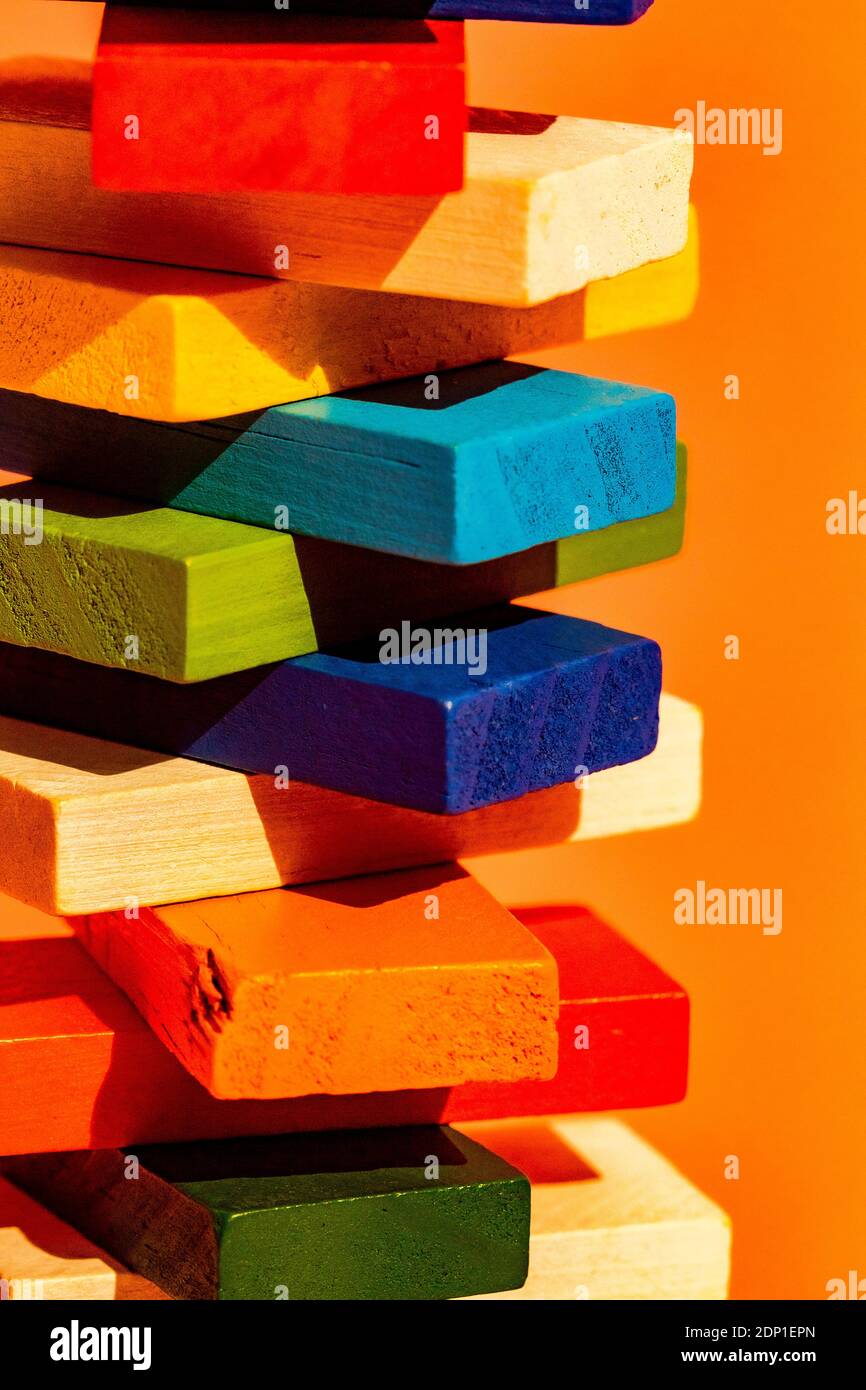 Stack of multi colored construction blocks against orange background ...