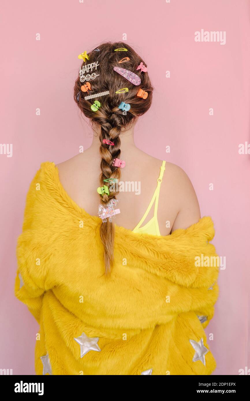 Teenage girl with various hair pins in her braid, rear view Stock Photo ...