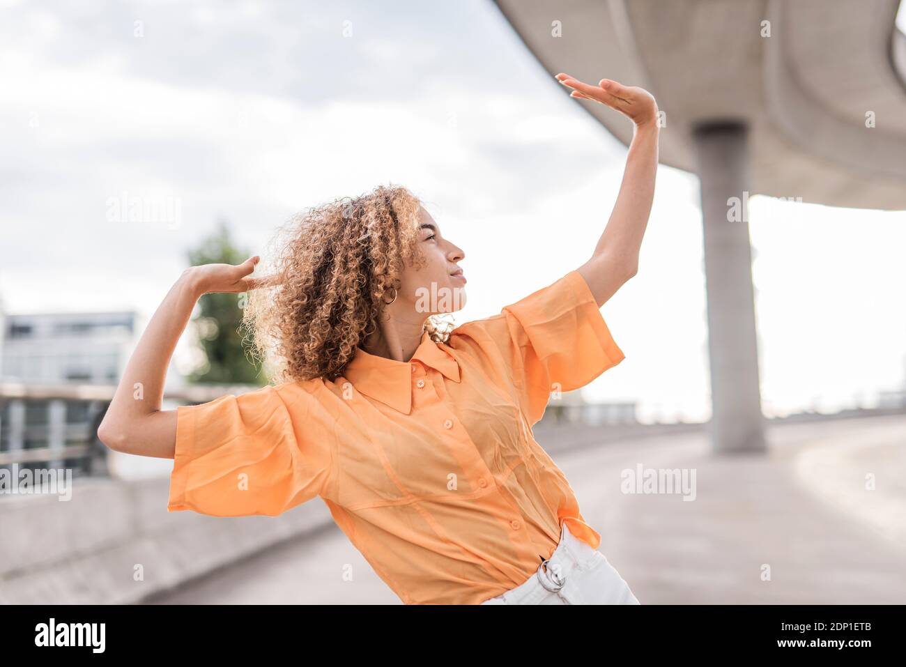 Young woman dancing outdoors orange hi-res stock photography and images ...
