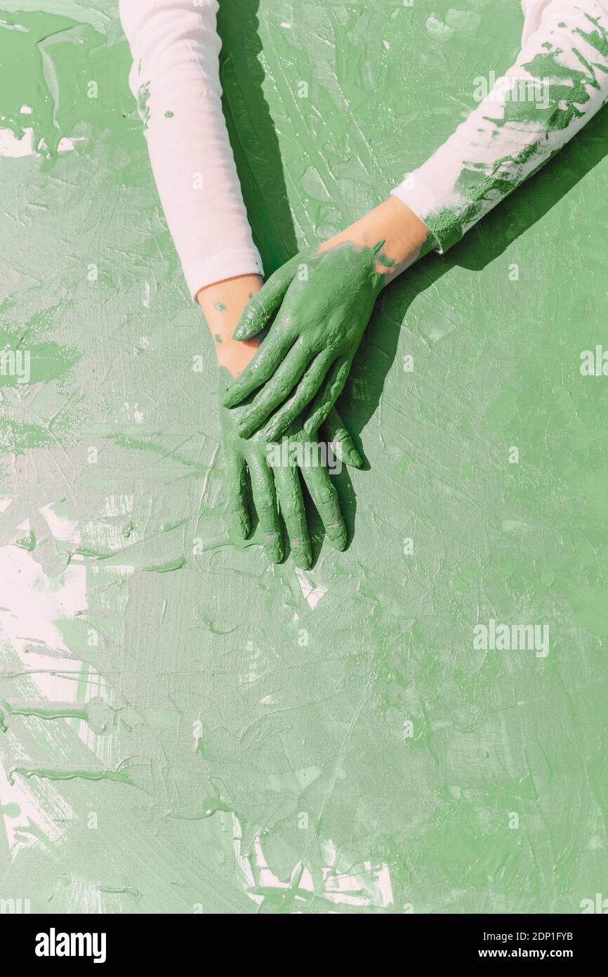 Green hands of young woman on green painting Stock Photo - Alamy