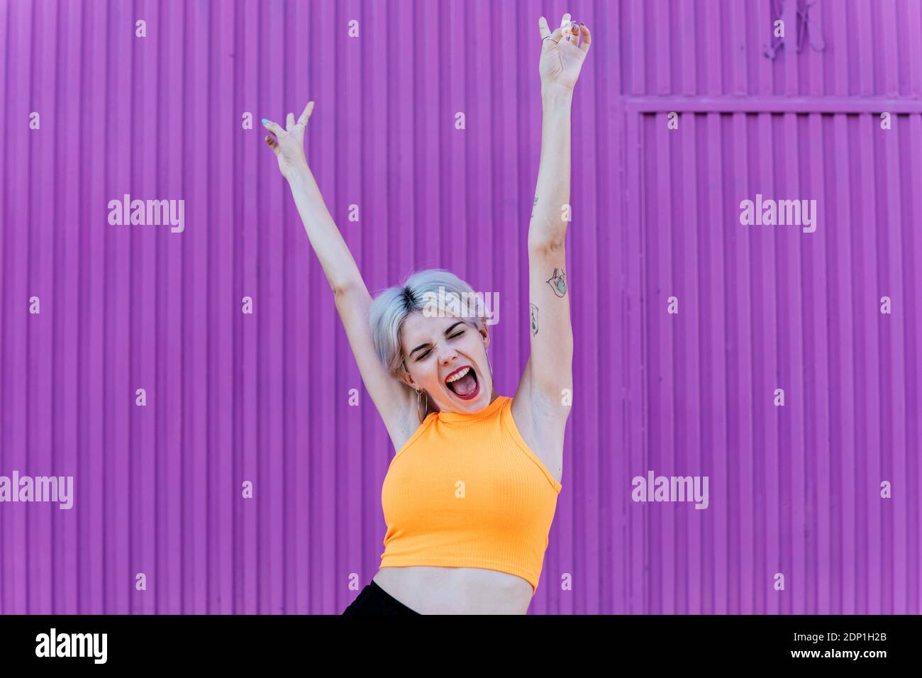 Portrait of woman with modern look and purple urban backgroundin ...