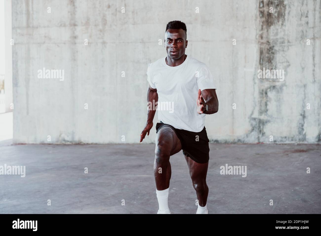 Active male athlete running against white wall Stock Photo - Alamy